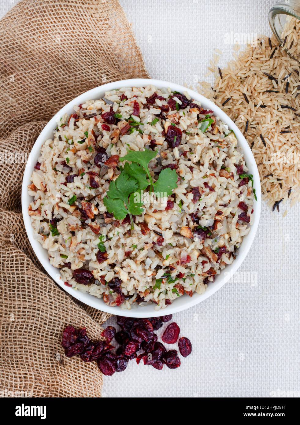 wild rice pilaf with cranberries and pecan nuts on rustic surface with ...