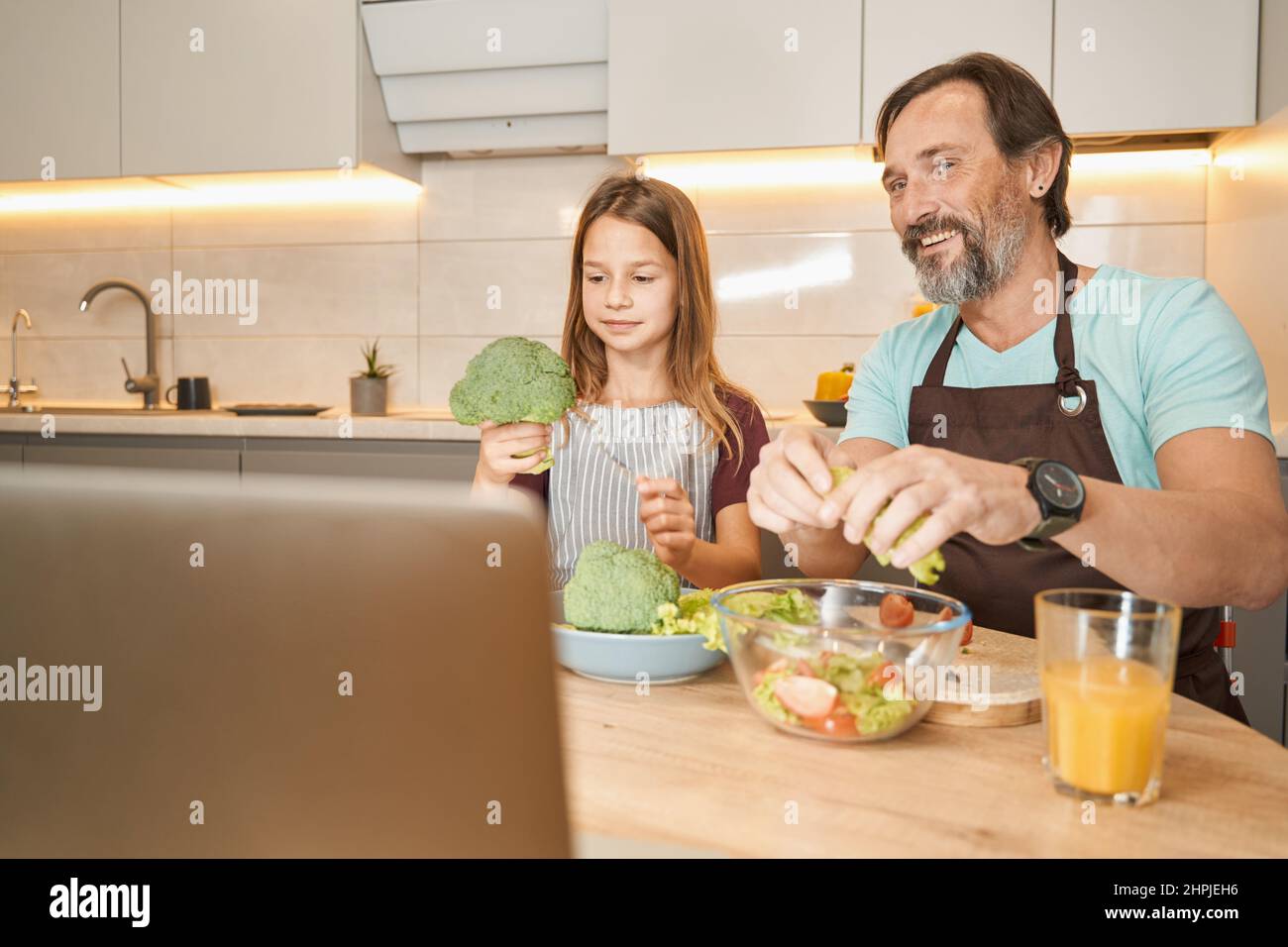 Adult man with a teenage girl cooking Stock Photo - Alamy