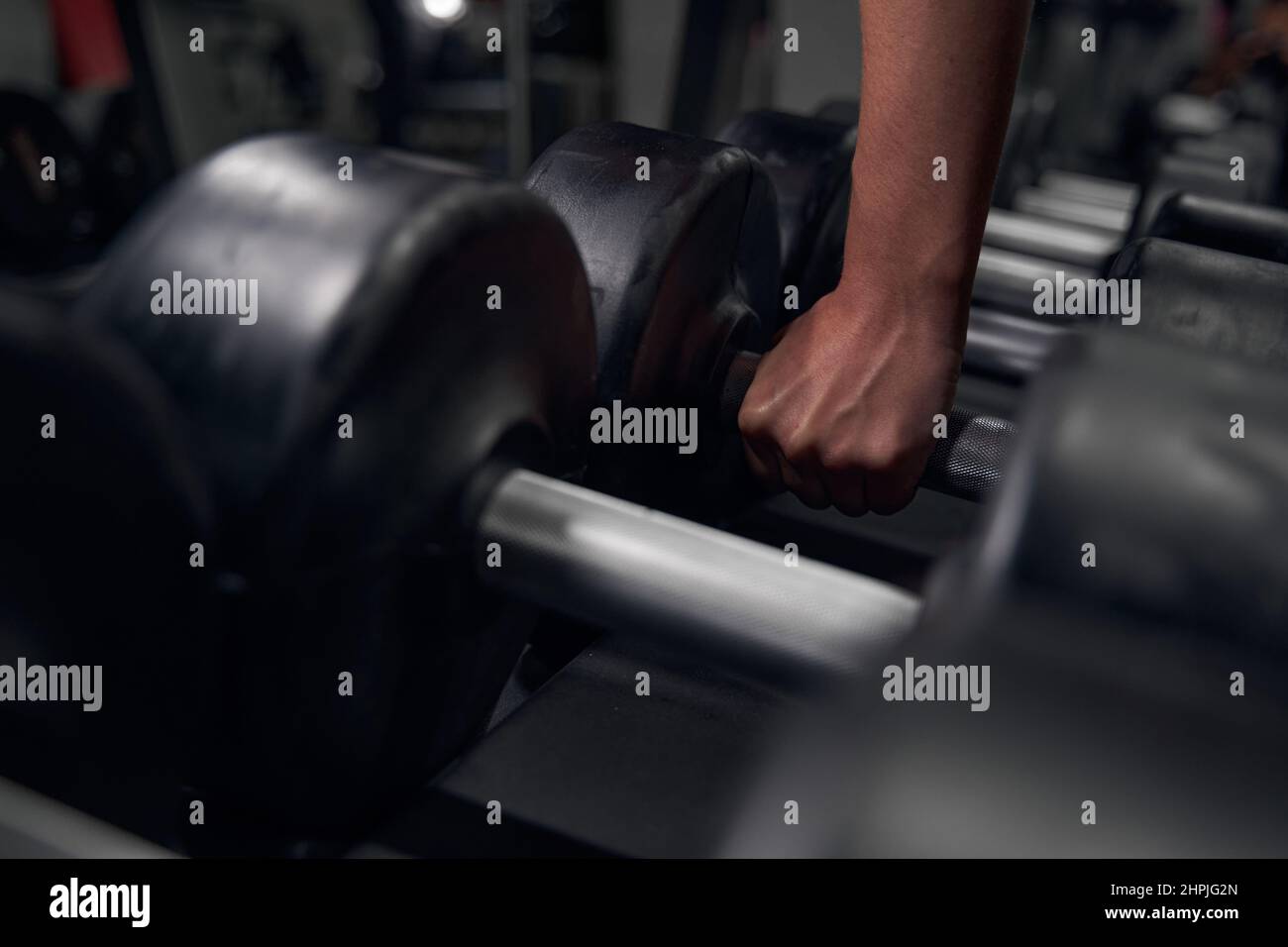 Focused photo on female hand that taking weights Stock Photo - Alamy