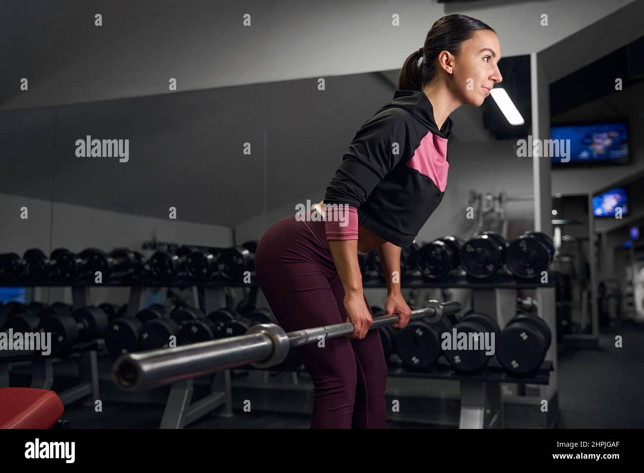 Strong young woman lifting weights in the gym Stock Photo - Alamy