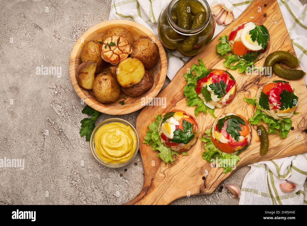 Portion of delicious chicken aspic on serving board on concrete table ...