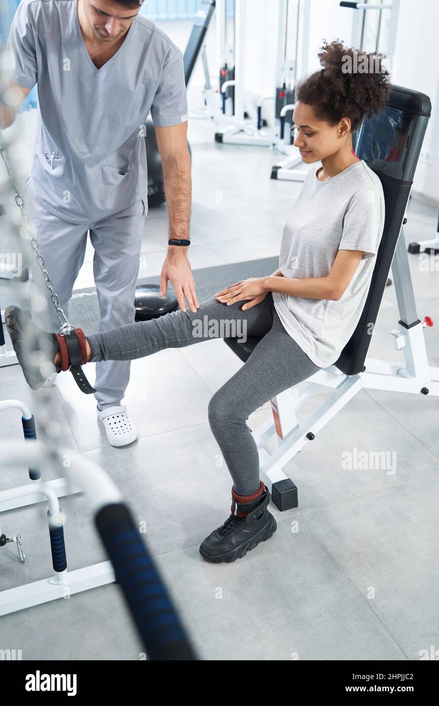 Woman undergoing leg rehabilitation in the gym Stock Photo - Alamy