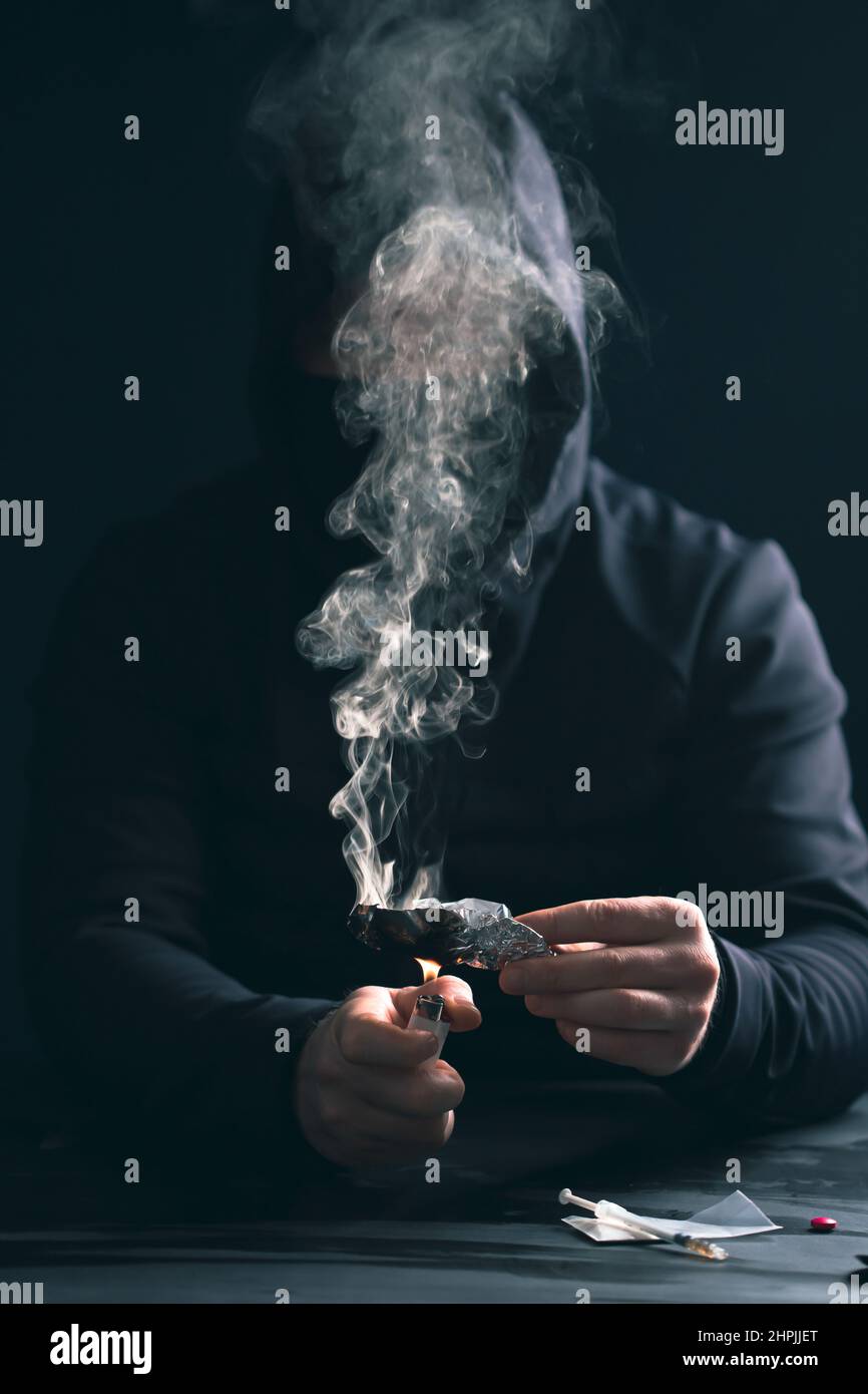 Addict/junkie man preparing drugs. The concept of crime and drug ...