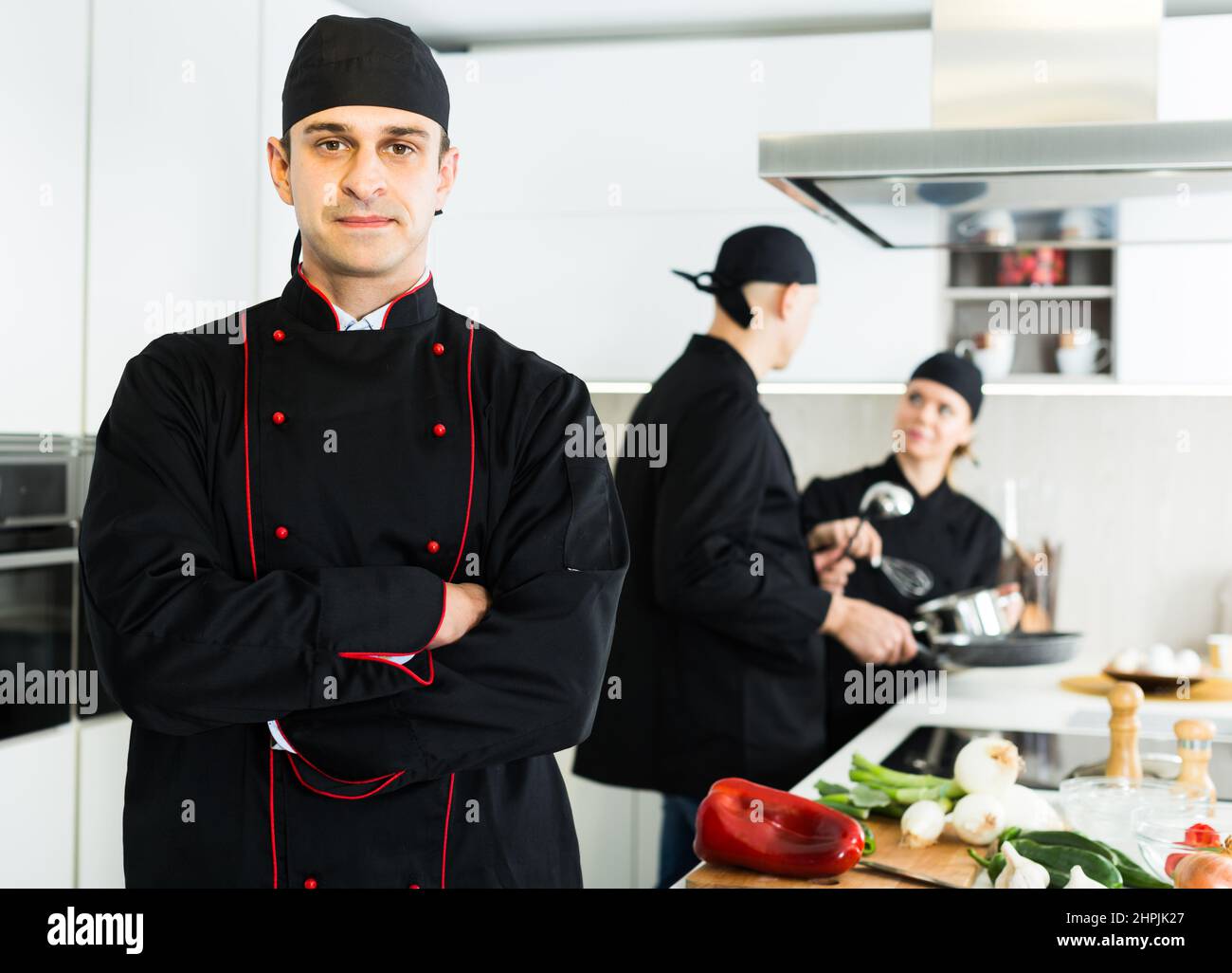 Smiling male kitchener in uniform is standing in the kitchen Stock ...