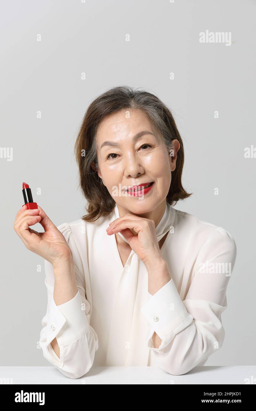 Asian Korean senior woman, bold and red cosmetics makeup beauty concept ...