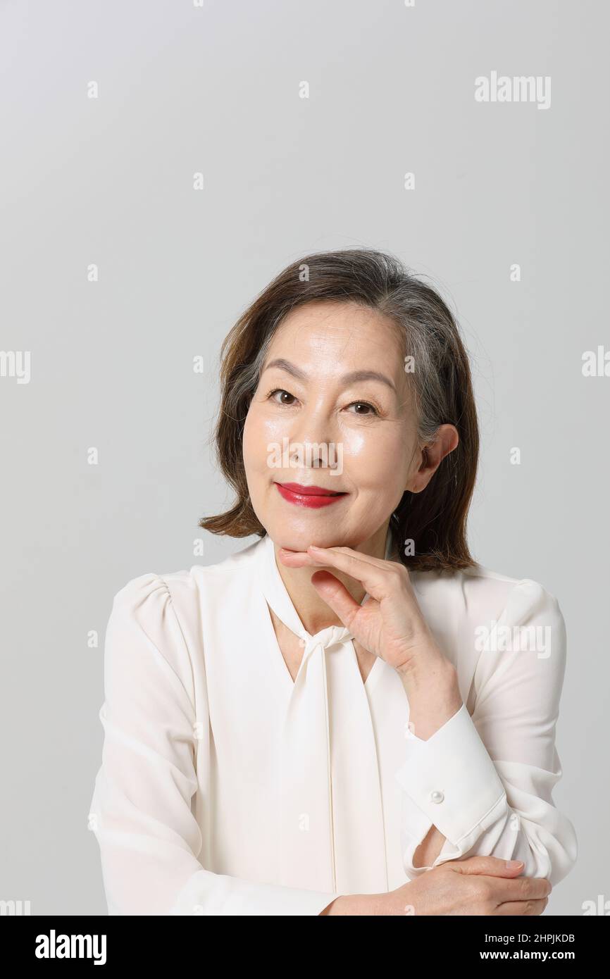 Asian Korean senior woman, bold and red cosmetics makeup beauty concept ...