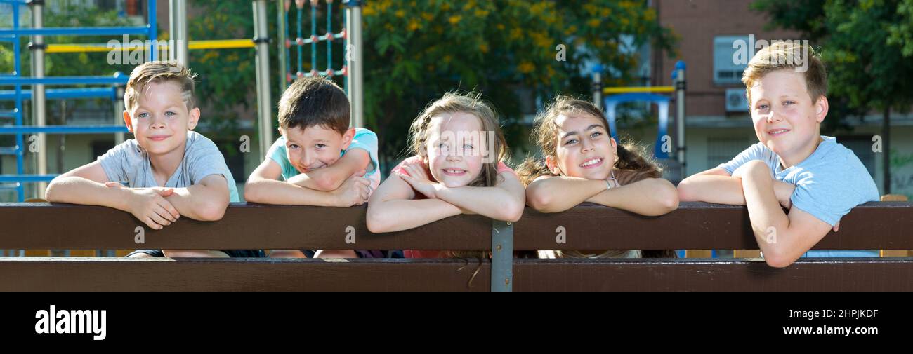 Glad children sitting on a bench Stock Photo - Alamy