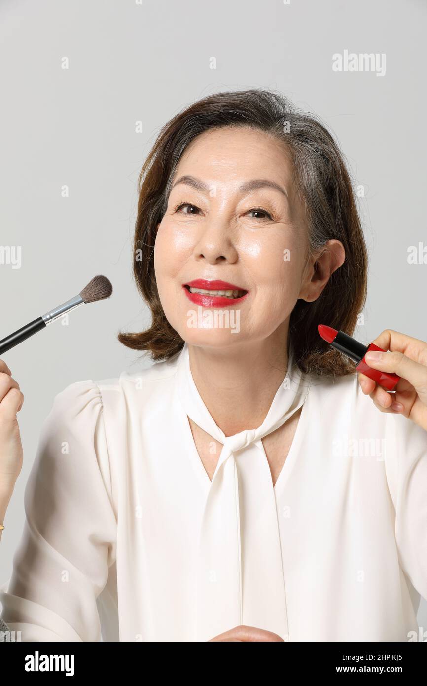 Asian Korean senior woman, bold and red cosmetics makeup beauty concept ...