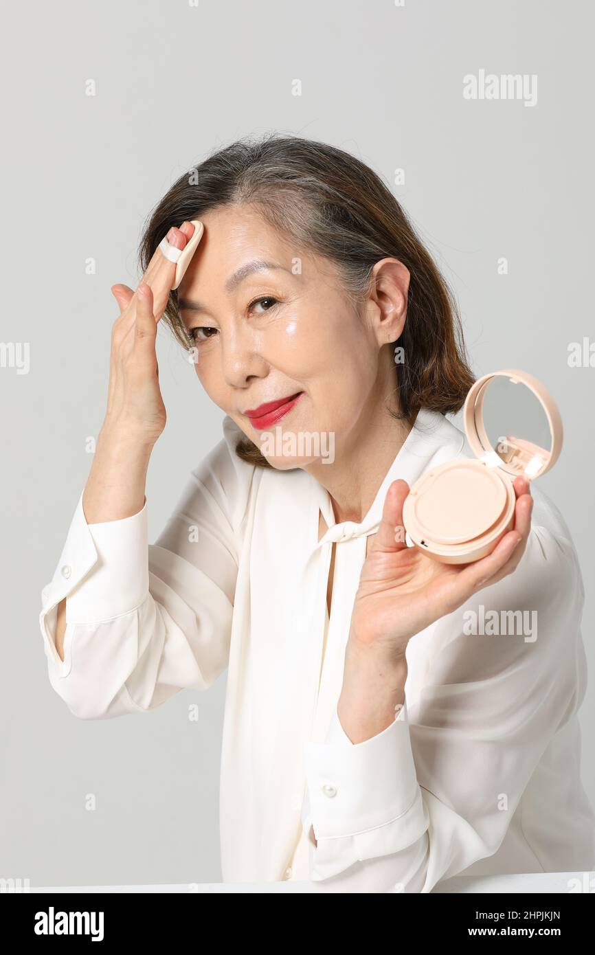 Asian Korean senior woman, bold and red cosmetics makeup beauty concept ...