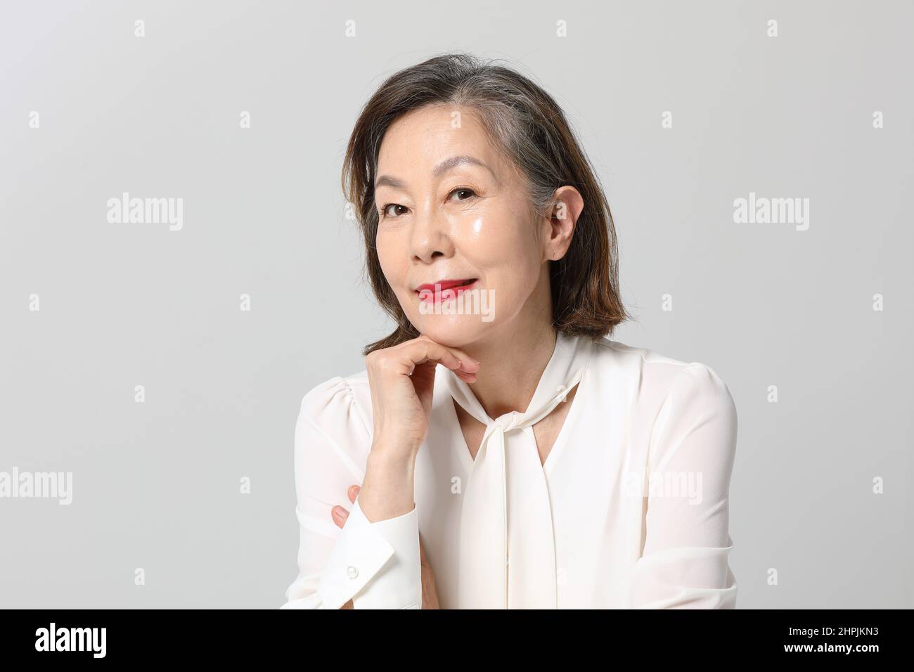 Asian Korean senior woman, bold and red cosmetics makeup beauty concept ...