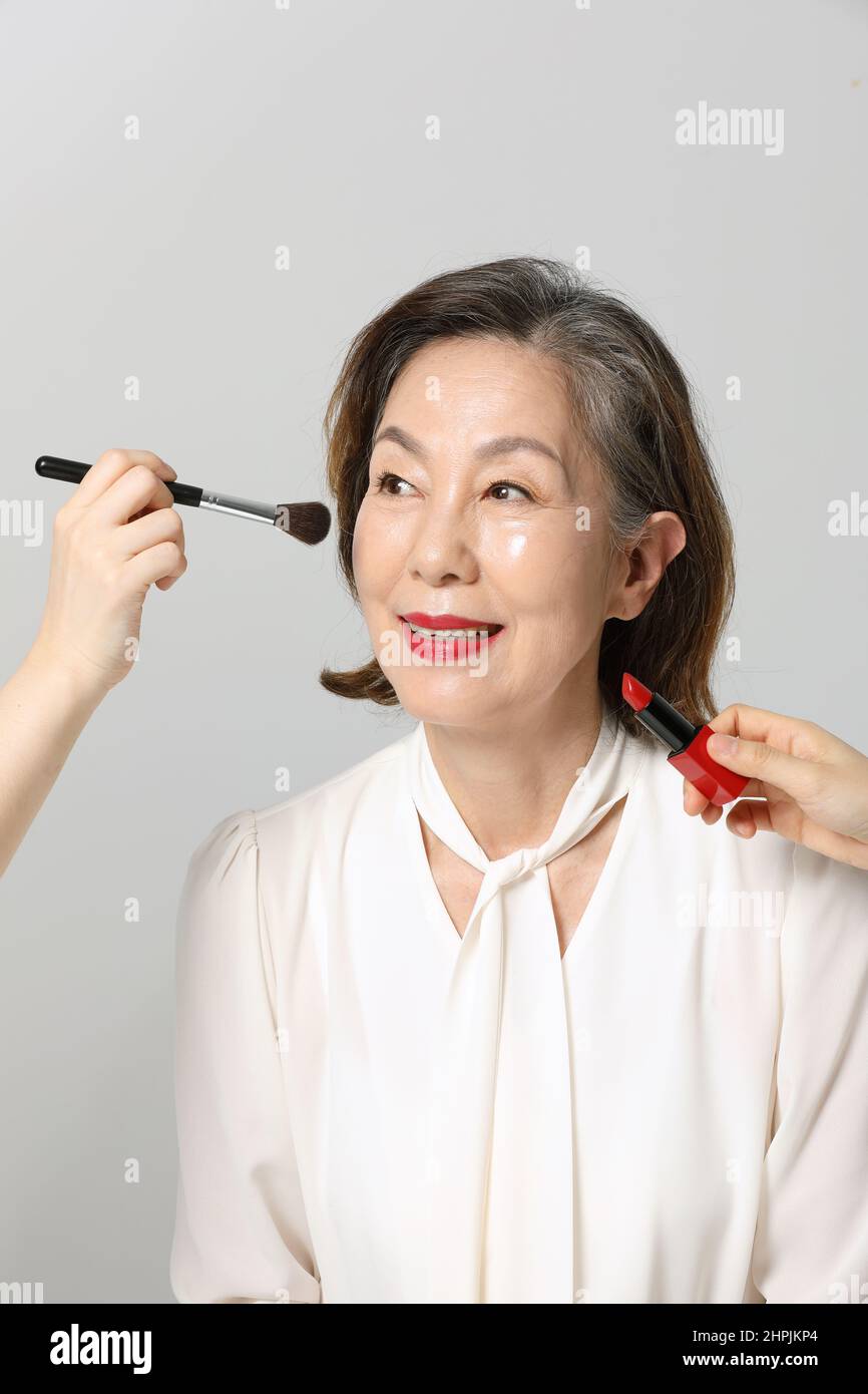Asian Korean senior woman, bold and red cosmetics makeup beauty concept ...
