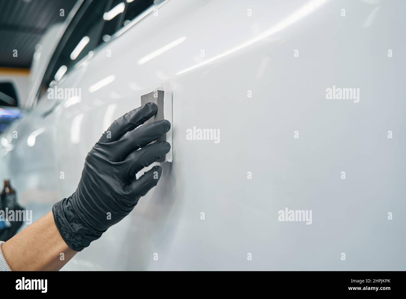 Gloved hand using buffing sponge block during car detailing Stock Photo ...