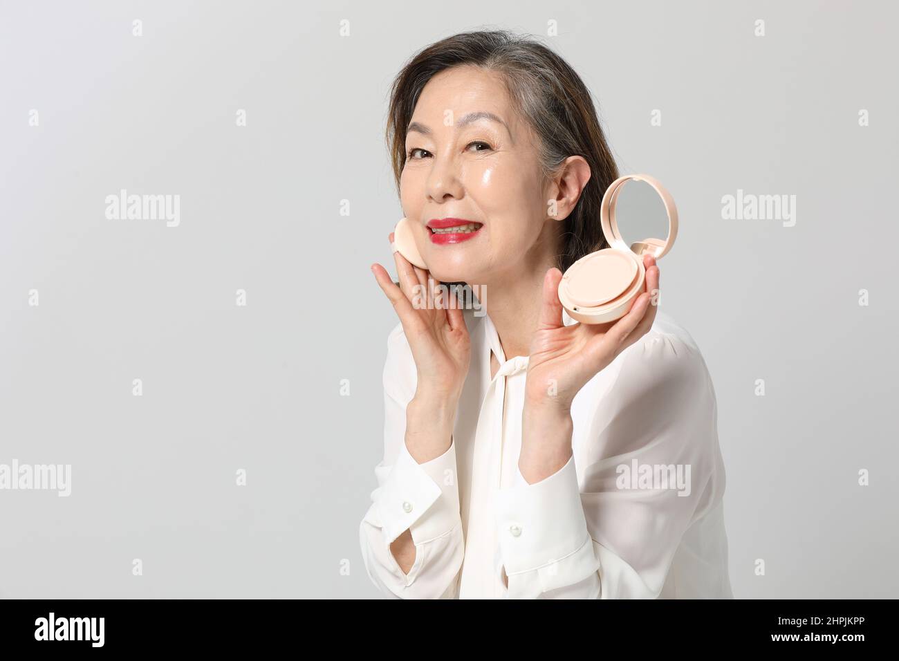 Asian Korean senior woman, bold and red cosmetics makeup beauty concept ...