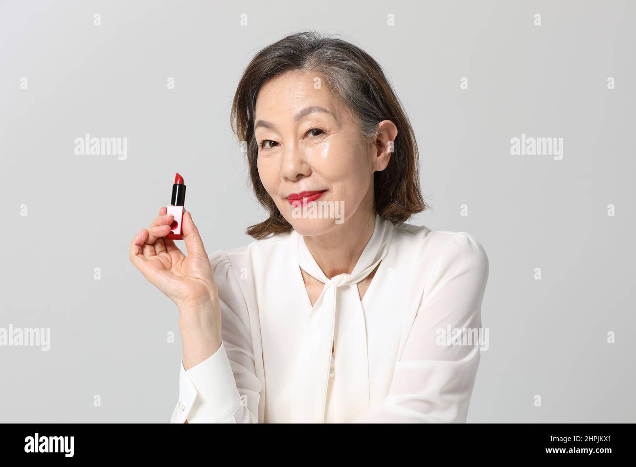 Asian Korean senior woman, bold and red cosmetics makeup beauty concept ...
