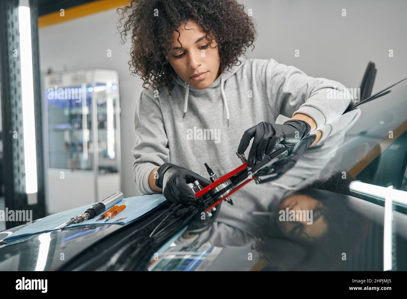 Serious mechanic installing bridge for windshield before injecting ...