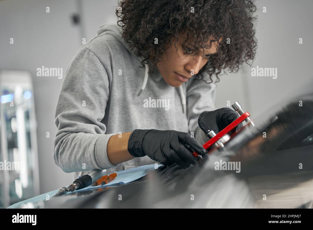 Worker installing windscreen bridge on auto glass Stock Photo - Alamy