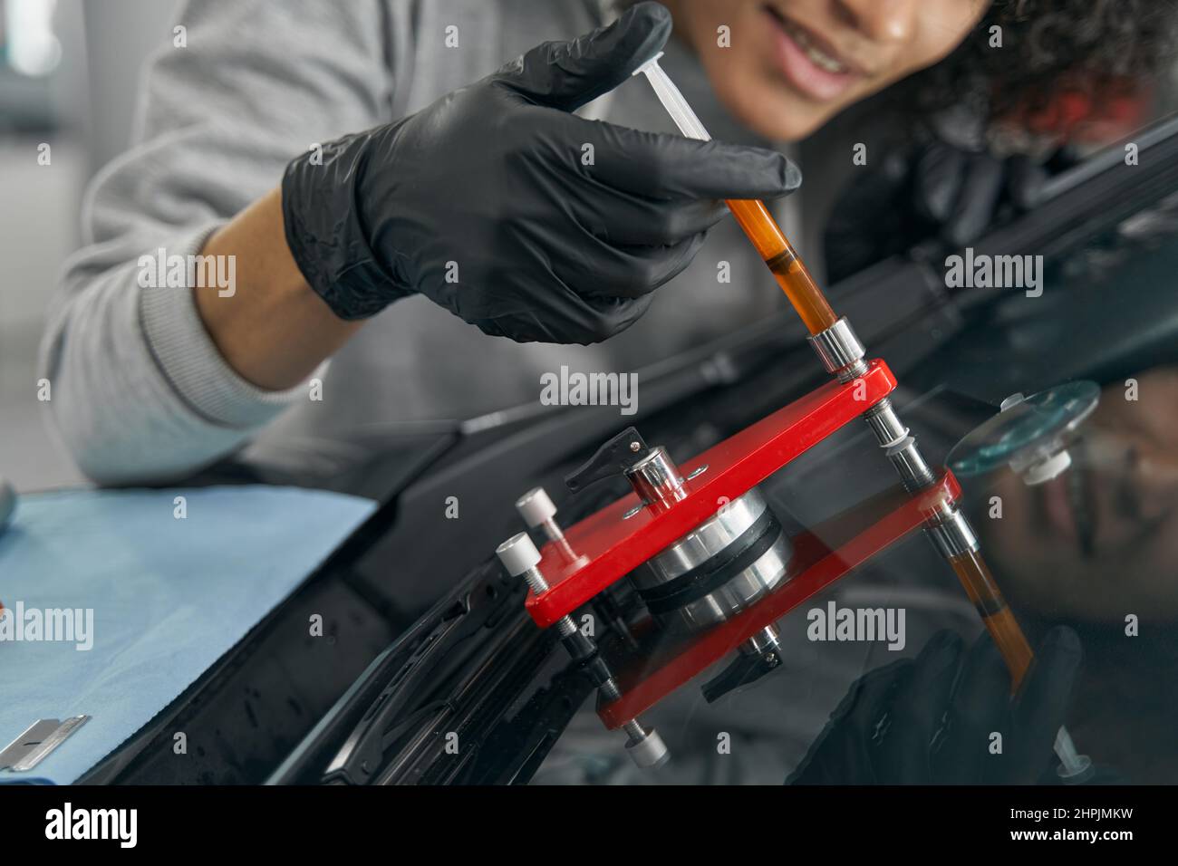 Pleased car mechanic injecting windshield resin into damaged area Stock ...