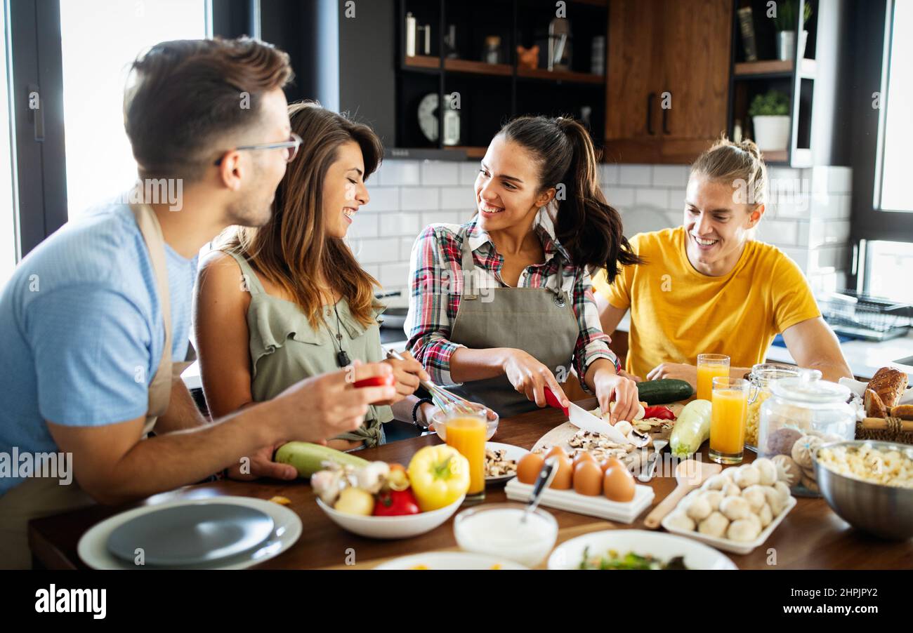 Beautiful happy people, friends is smiling while cooking together in ...
