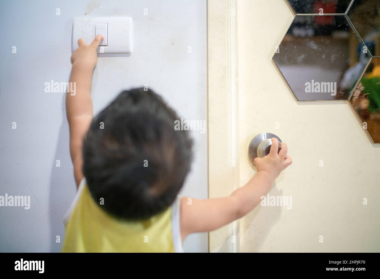 Baby boy playing electric socket lamp plug in room danger child Stock ...