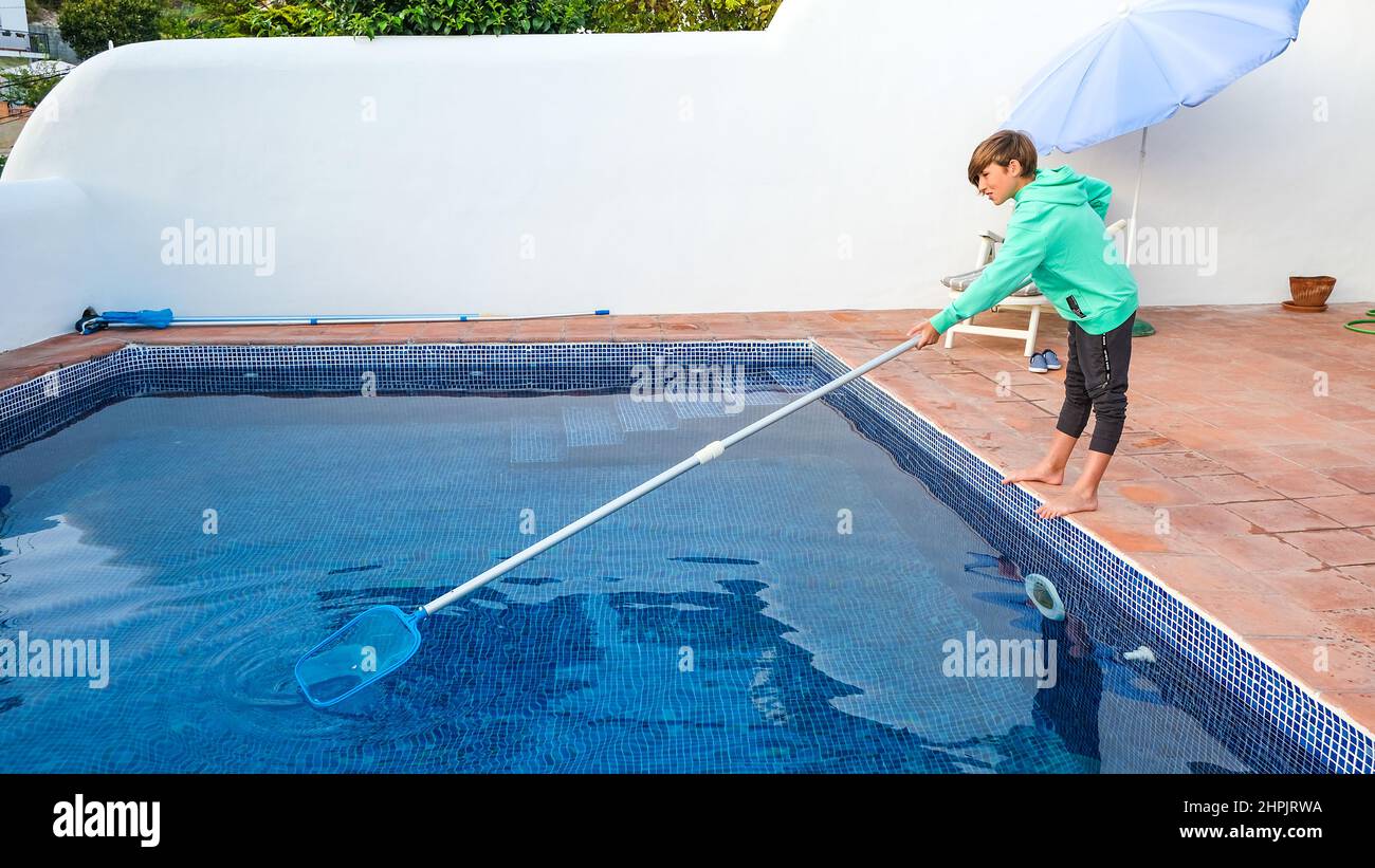 Boy cleaning swimming pool. Teenager after school and house help job ...
