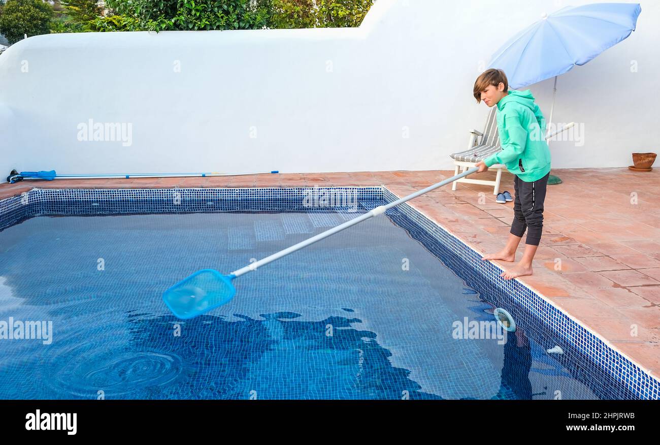Boy cleaning swimming pool. Teenager after school and house help job ...
