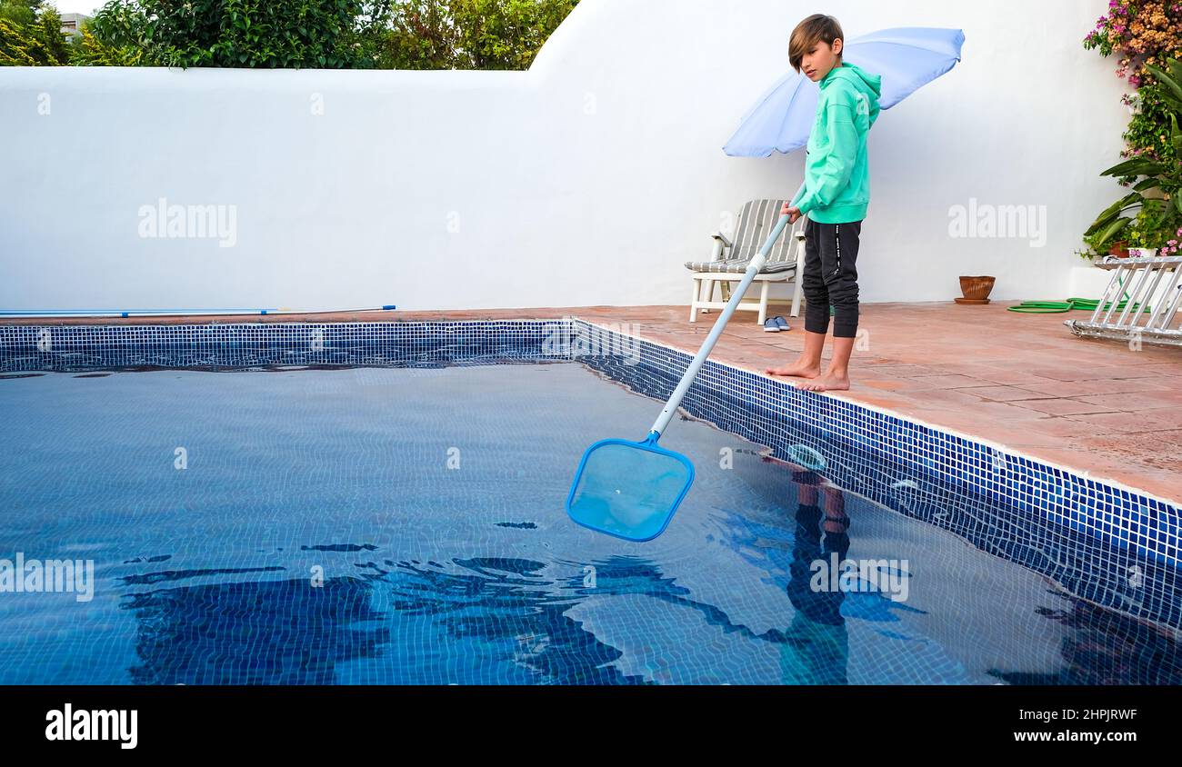 Boy cleaning swimming pool. Teenager after school and house help job ...