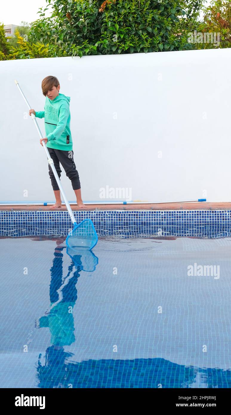 Boy cleaning swimming pool. Teenager after school and house help job ...