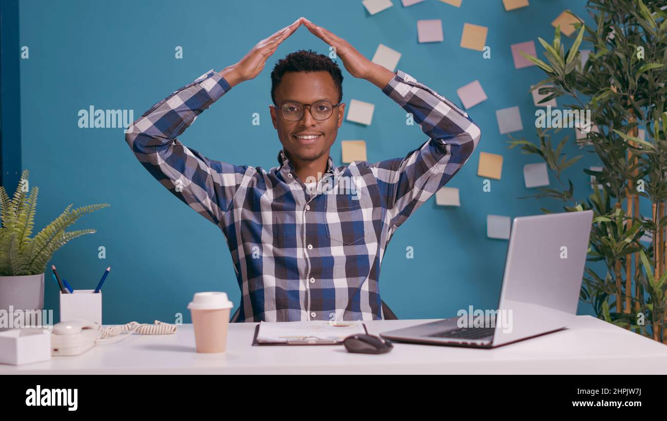 Confident person doing house roof symbol feeling safe inside, sitting ...