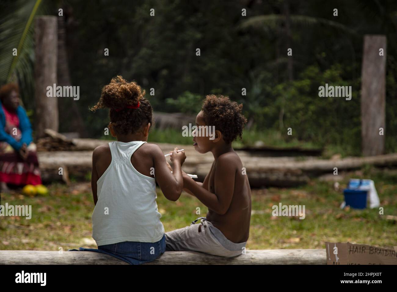 Children sitting on a log in a small island community at Mare Island ...