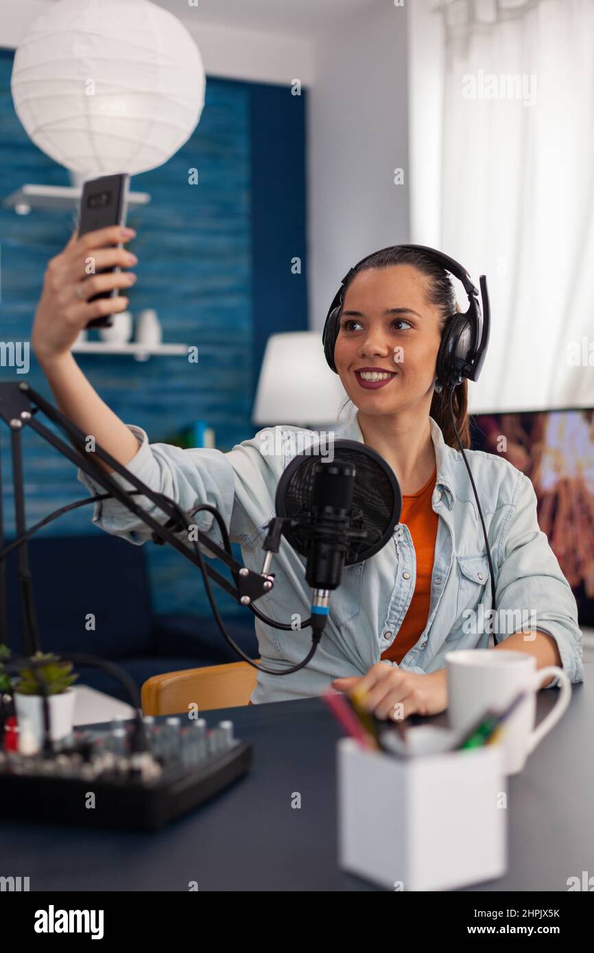 Woman influencer in home studio streaming live on smartphone. Content ...