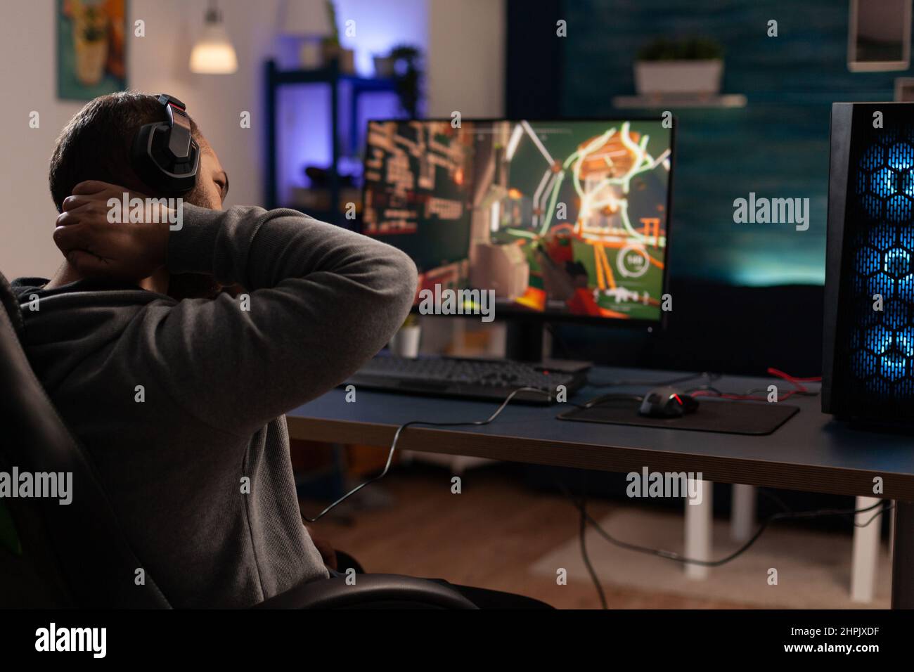Adult preparing to play video games on monitor, using headphones and ...