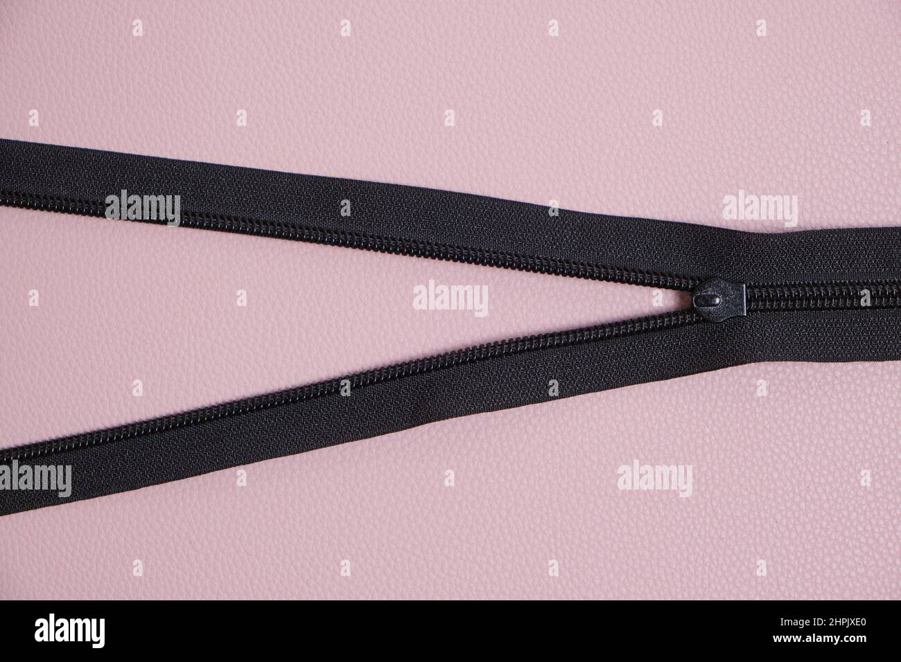 Zipper is black on a pink background Stock Photo - Alamy