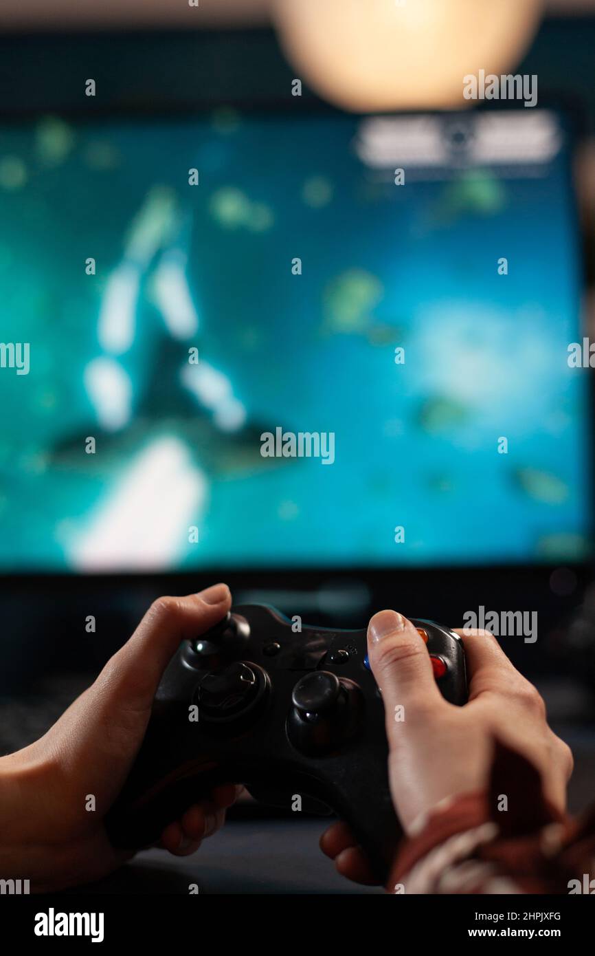 Close up of woman holding joystick and playing video games on computer ...