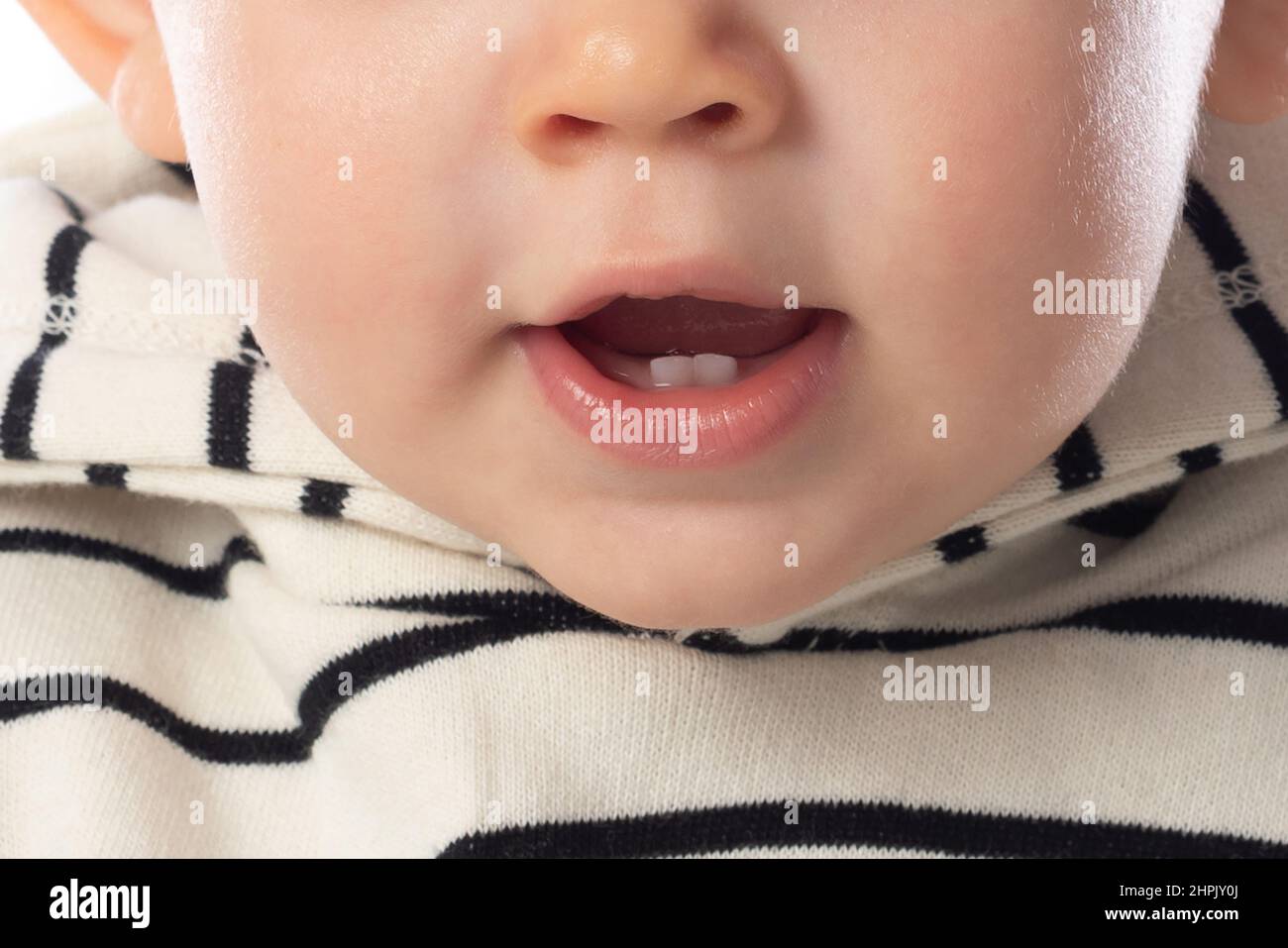 Little smiling baby with two new teeth isolated on a white background ...