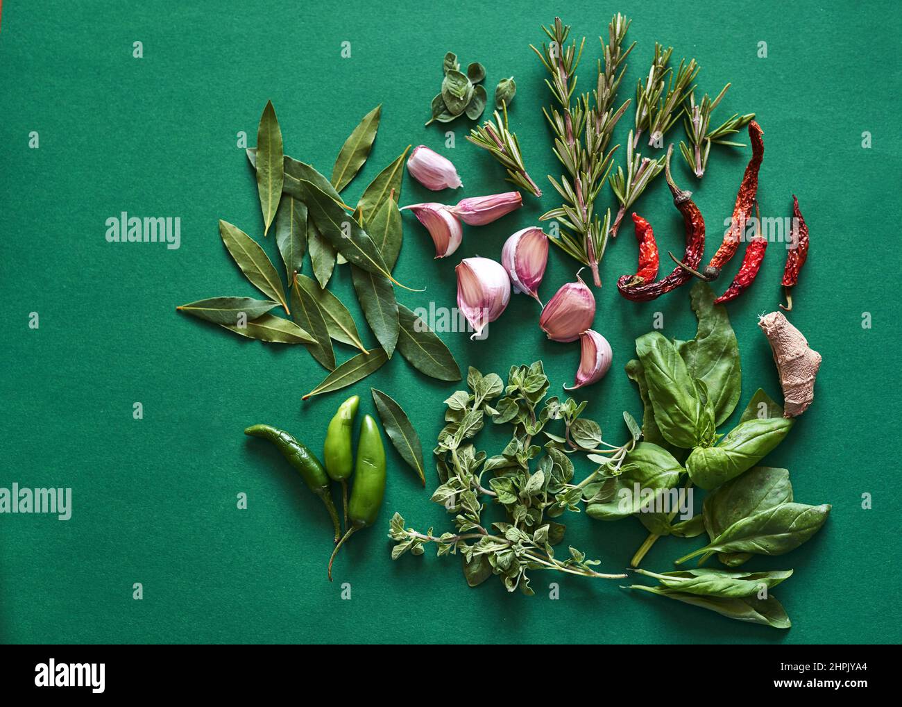 Fresh herbs and spices on a green background Stock Photo - Alamy