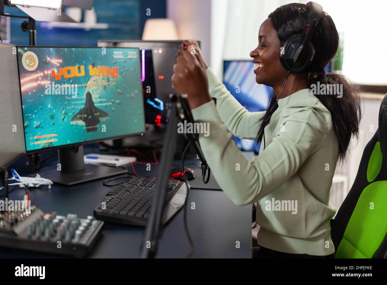 Happy african american woman gamer wearing headset winning videogames ...
