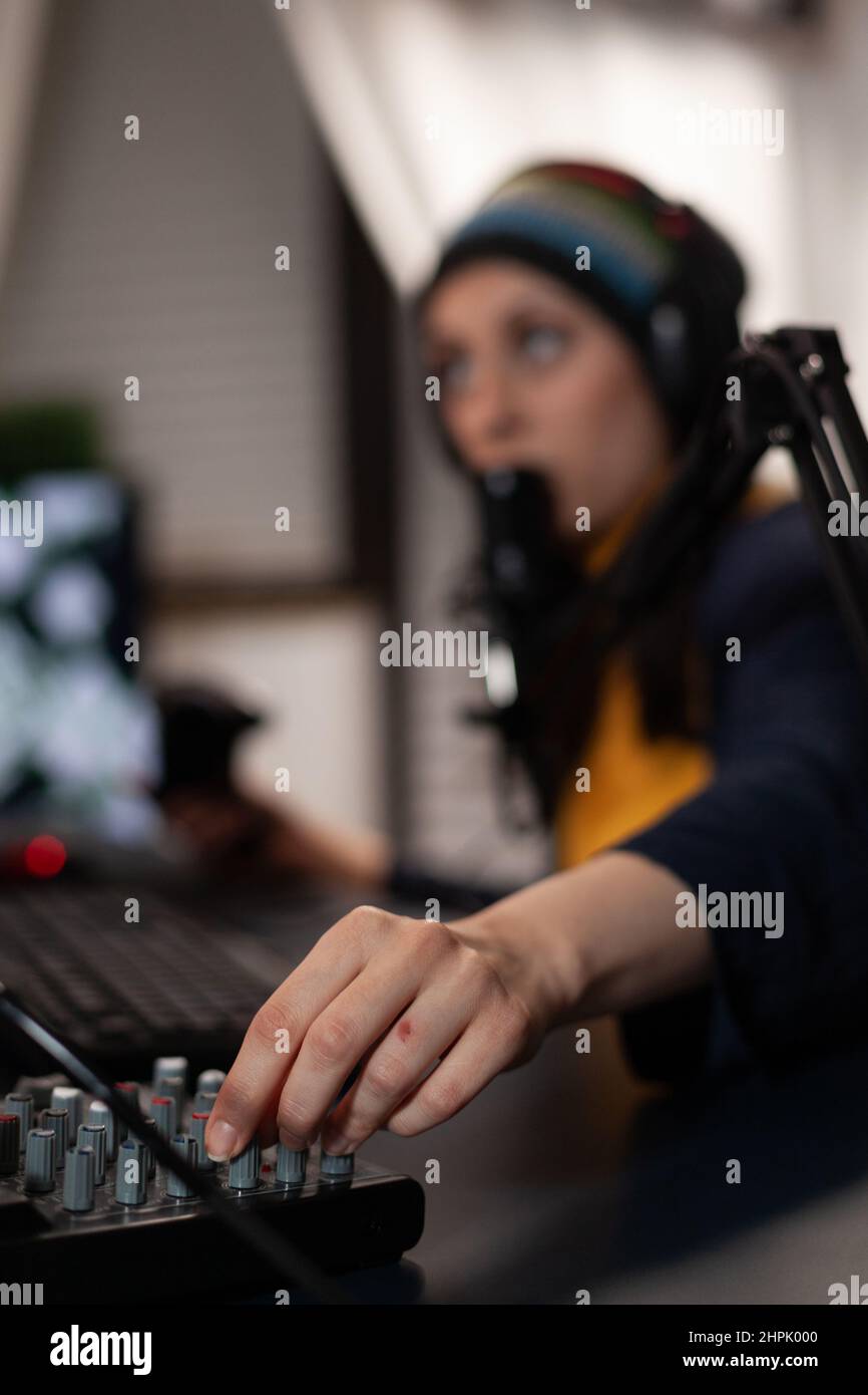 Close up of adult using streaming equipment on desk with headphones and ...