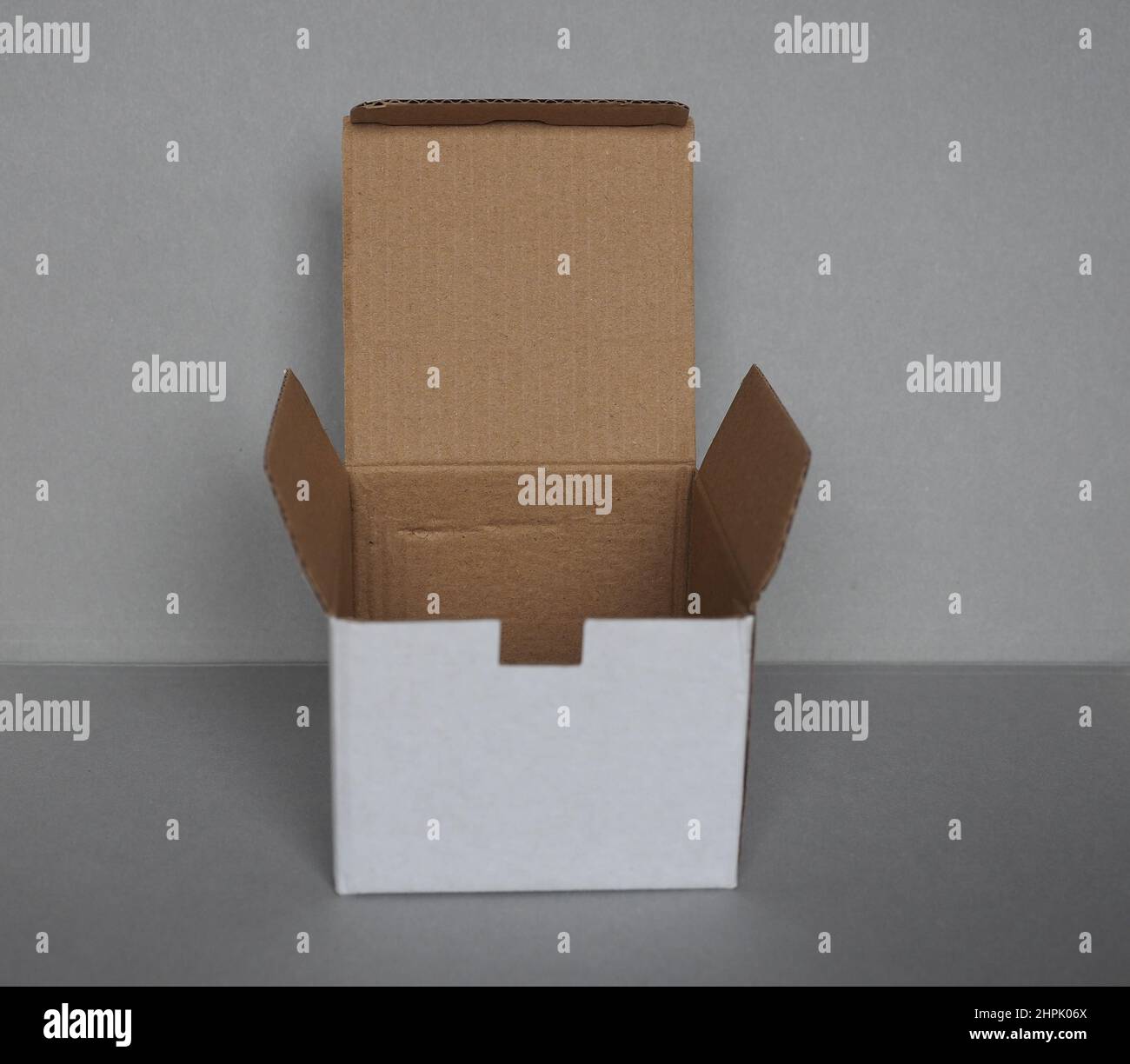 empty cardboard box in front of grey wall Stock Photo - Alamy