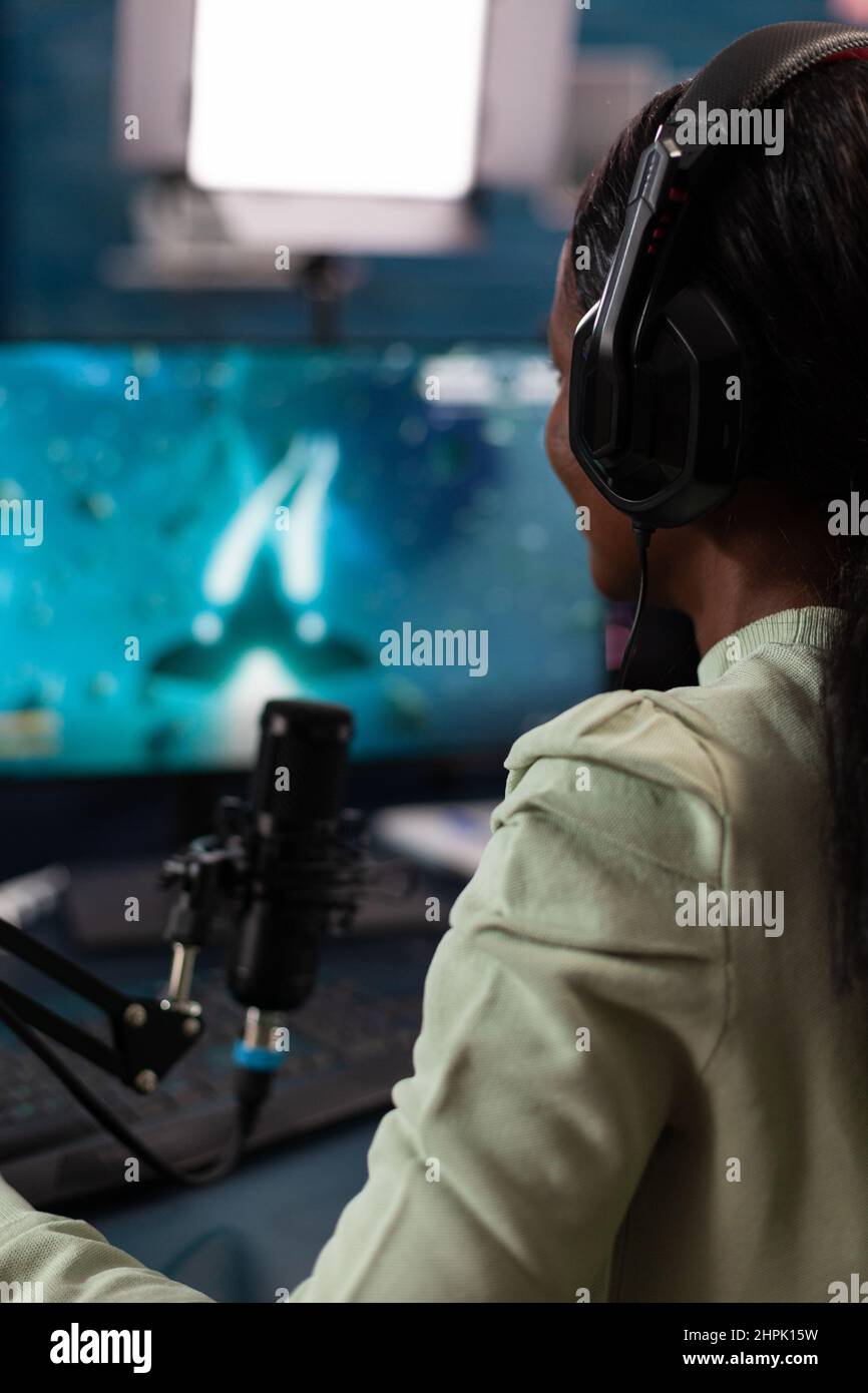 Successful gamer woman with gaming headset while playing online ...
