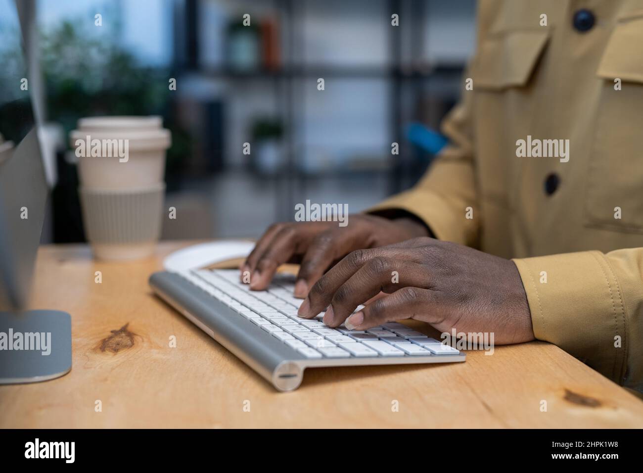 Hands of young African-American businessman pressing keys of computer ...