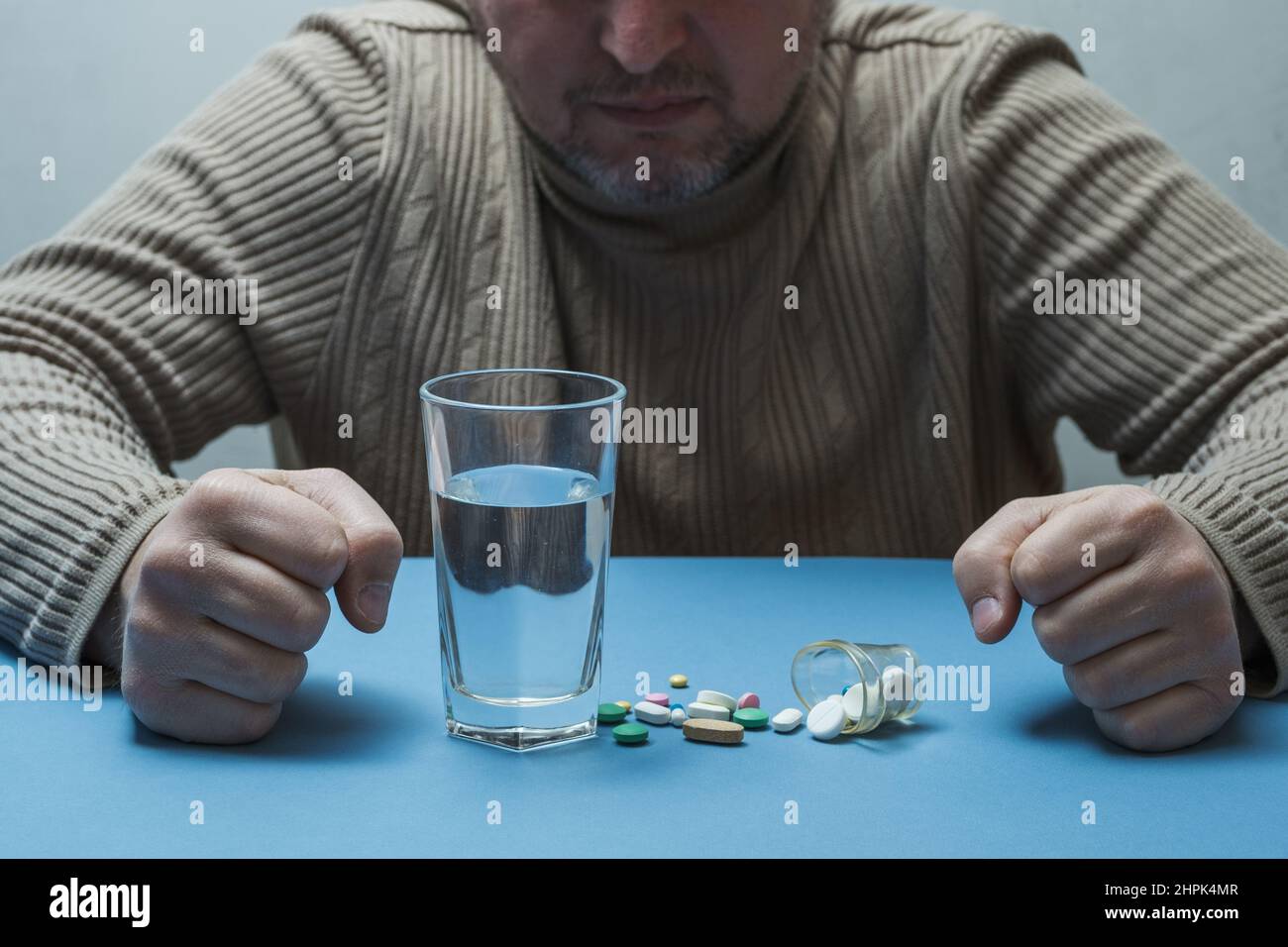 The man clenches his hands into fists, medical preparations and a glass ...
