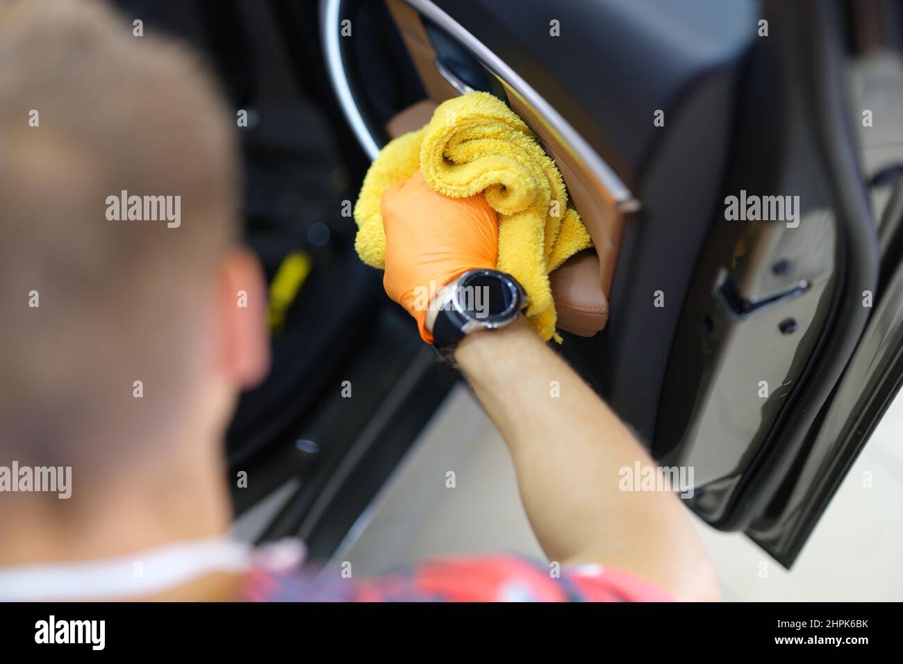 Master wiping leather doors with microfiber rag closeup Stock Photo - Alamy