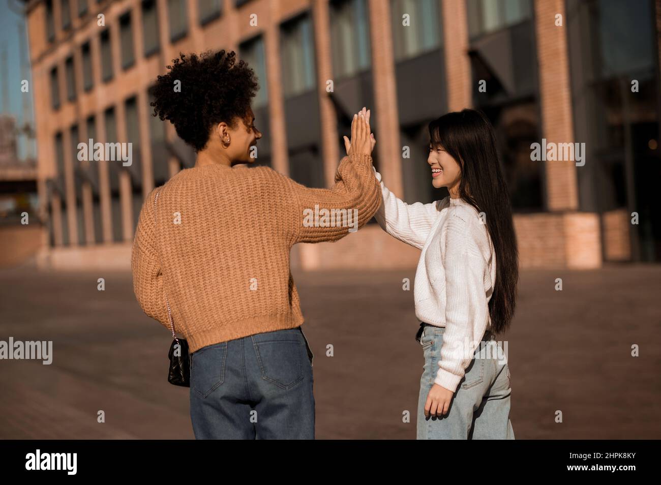 Two pretty girls walking and talking, feeling joyful Stock Photo - Alamy