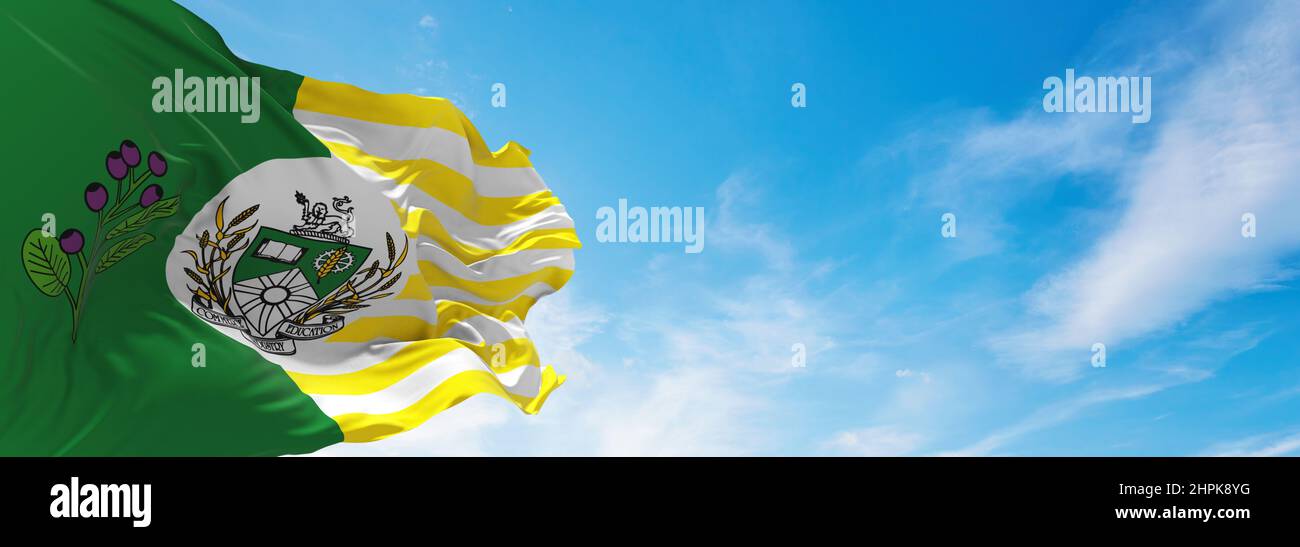 flag of Saskatoon , Canada at cloudy sky background on sunset ...