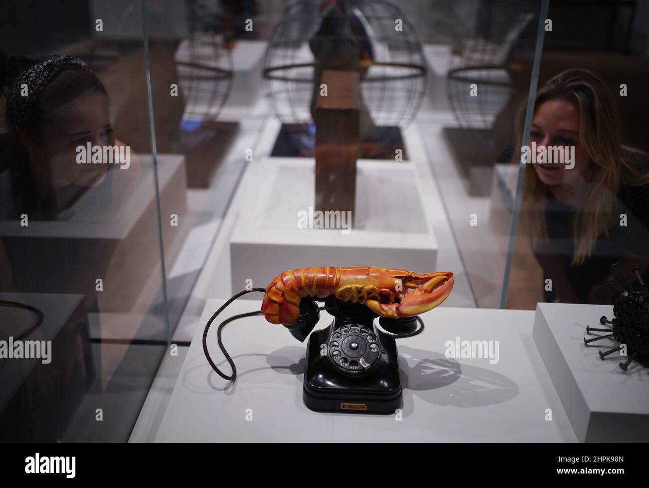 Gallery staff members looking at a Bakelite telephone with a plaster ...