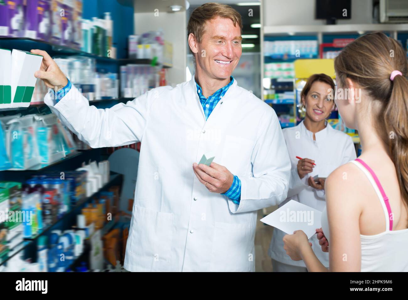 Smiling pharmacist helping customers Stock Photo - Alamy