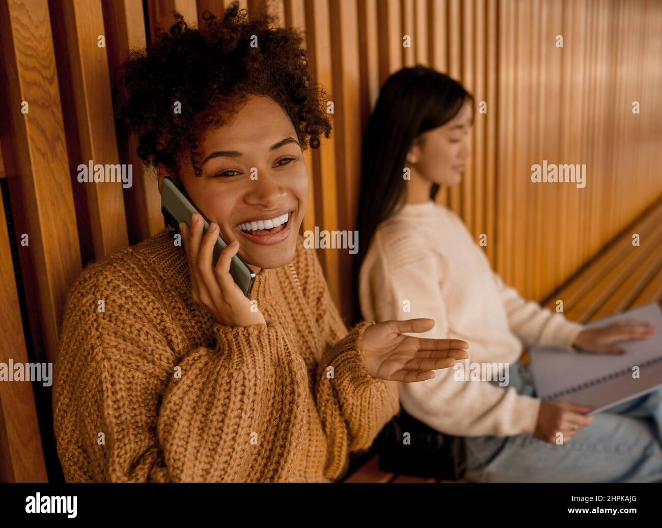 Two girls talking on bench hi-res stock photography and images - Alamy
