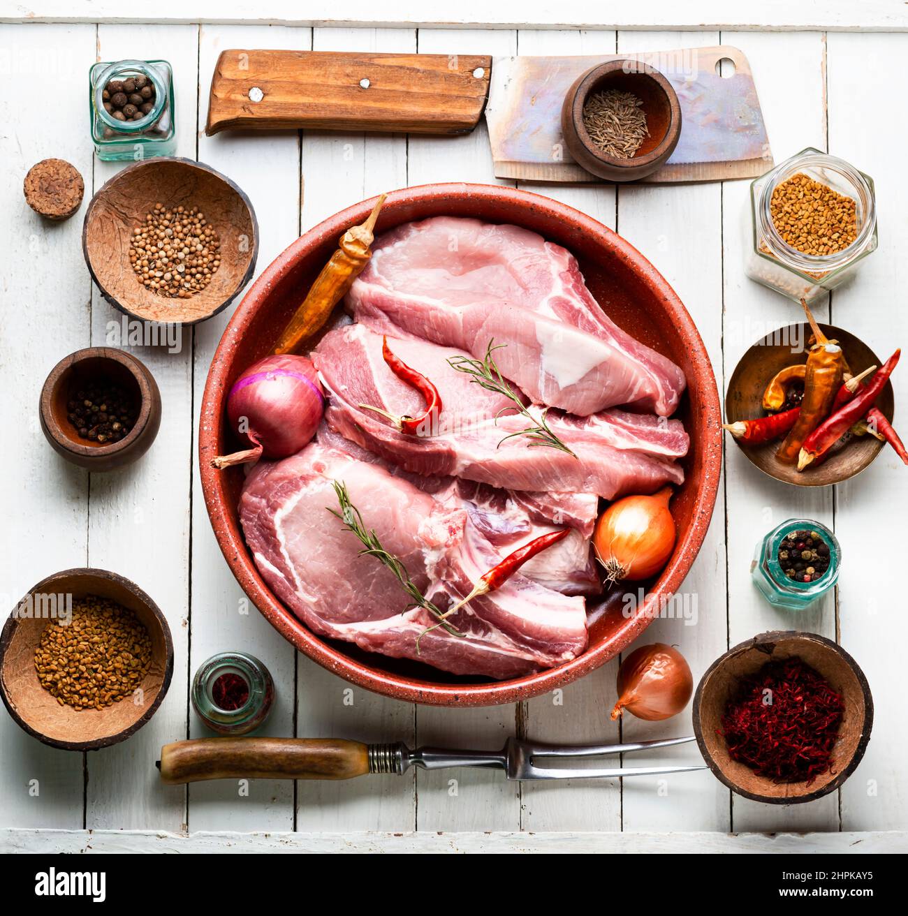 Fresh, raw pork meat on the bone. Raw chop on the bone and seasoning ...