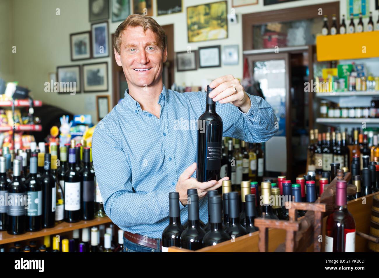 customer picking bottle in wine store Stock Photo - Alamy