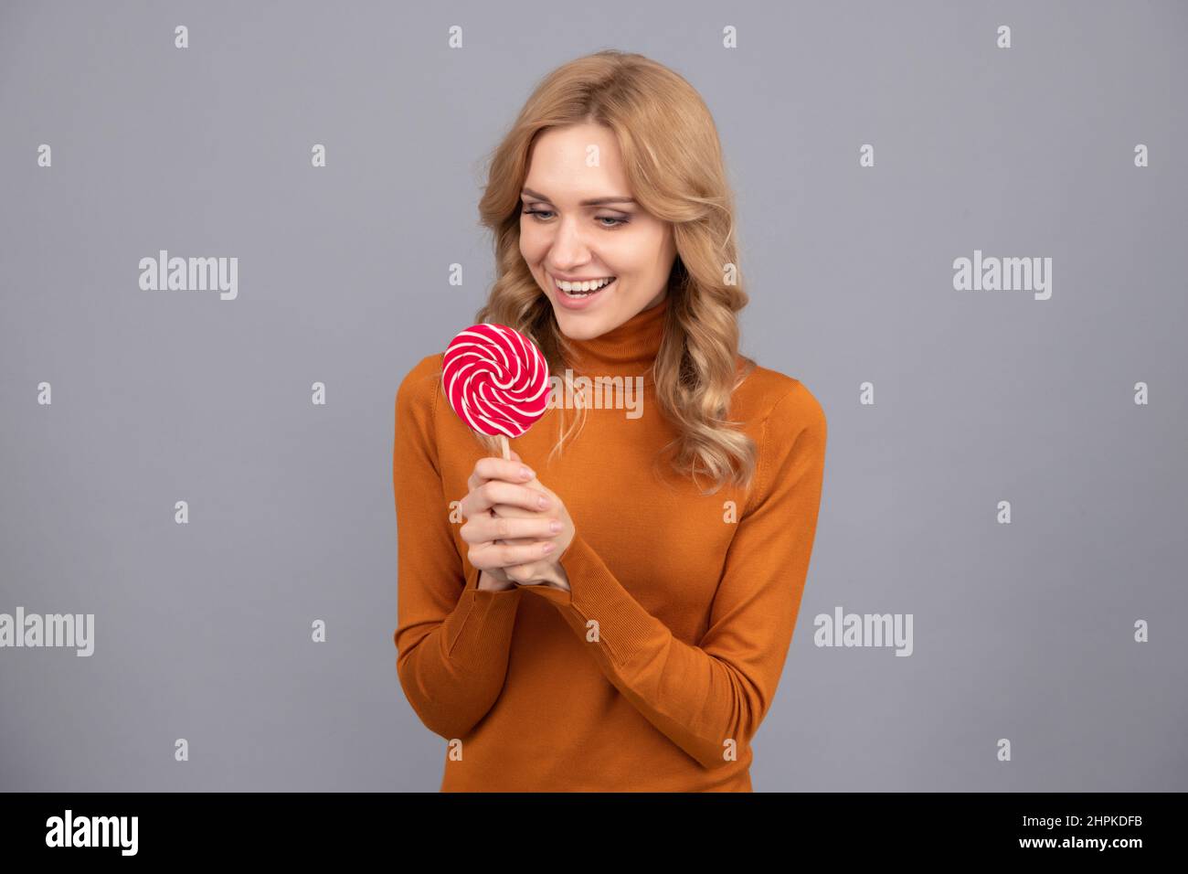 You deserve a lollipop today. Happy woman hold lollipop grey background ...